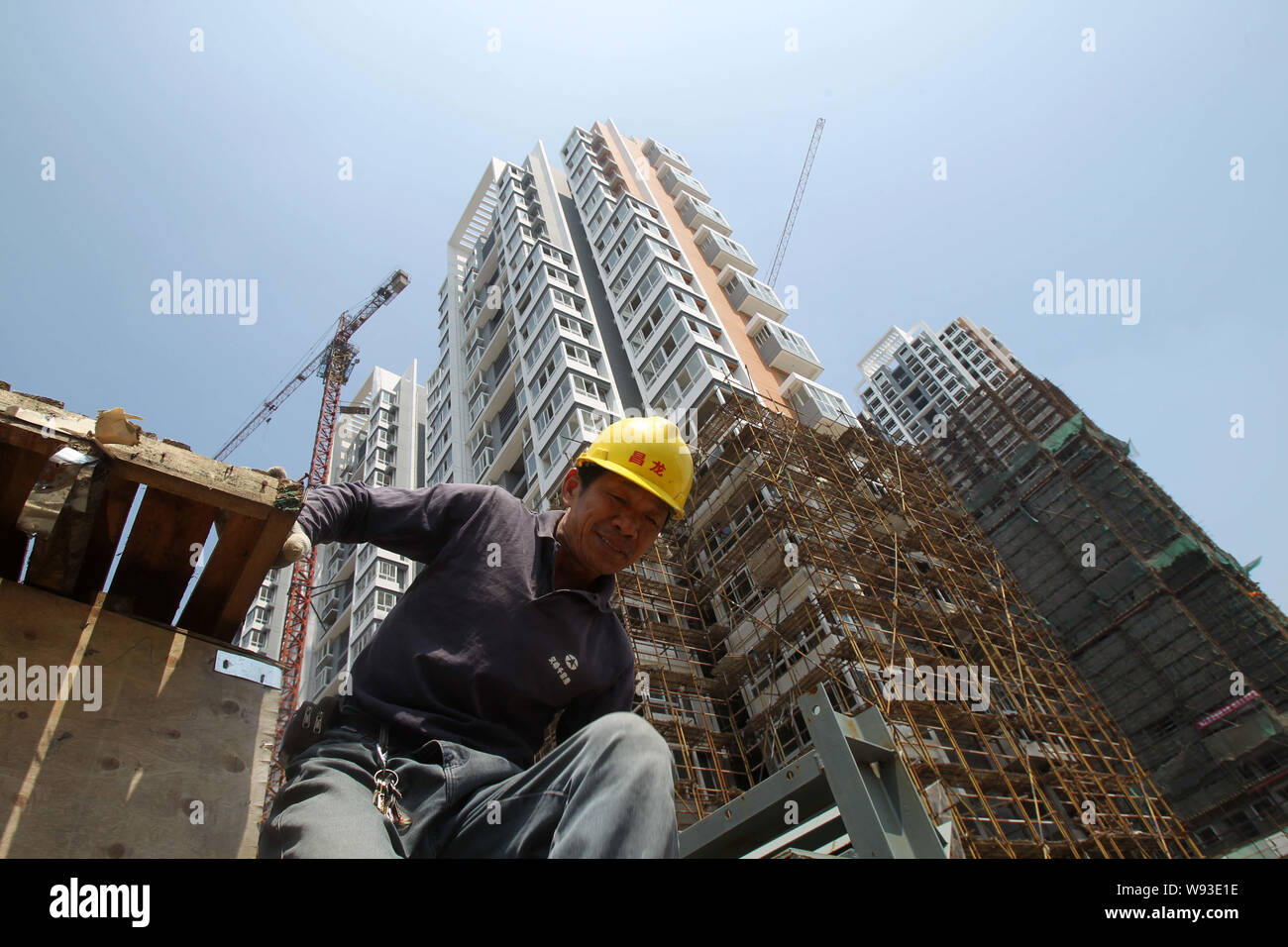 --FILE--A Chinese migrant worker labors at the construction site of a ...