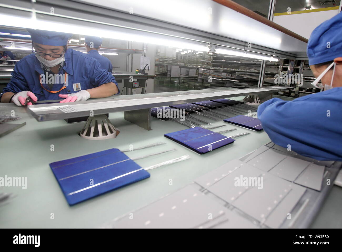 --FILE--Chinese workers weld photovoltaic cells for solar panels at a ...