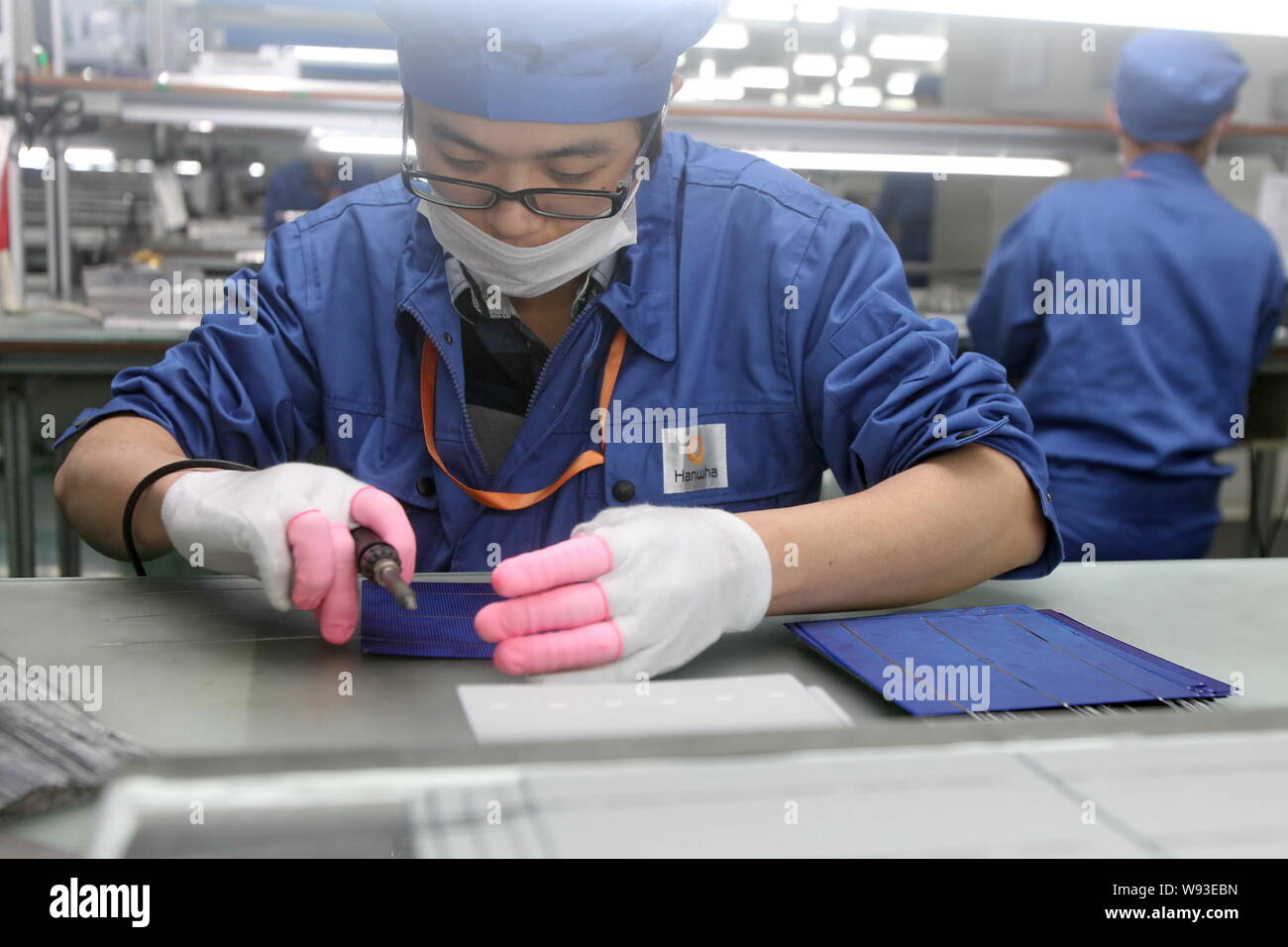 --FILE--Chinese workers weld photovoltaic (PV) cells to make solar ...