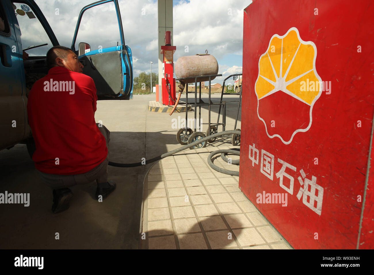 --FILE--A Chinese driver refuels his truck at a gas station of CNPC ...