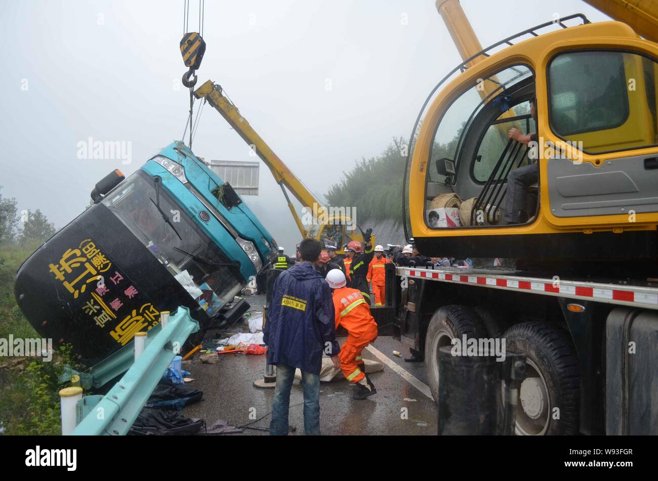 A crane vehicle lifts a passenger bus after a crash that killed 2 and ...