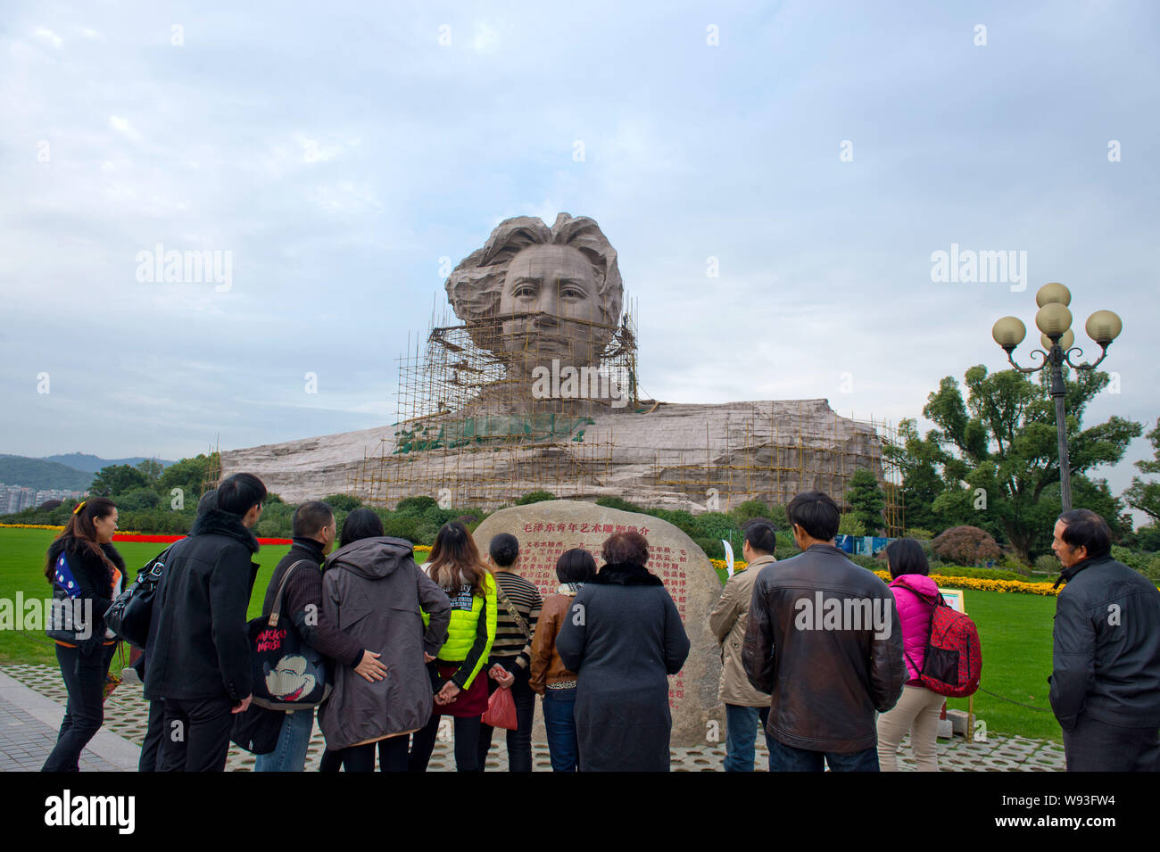 --FILE--Visitors look at the giant statue portraying former Chinese ...