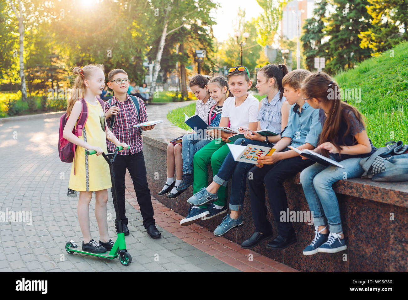 Happy Schoolmates Portrait. Schoolmates seating with books in a wooden ...