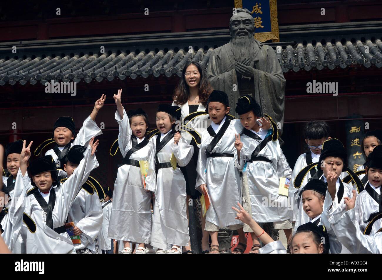 First-grade pupils wearing traditional Chinese uniforms pose with a ...