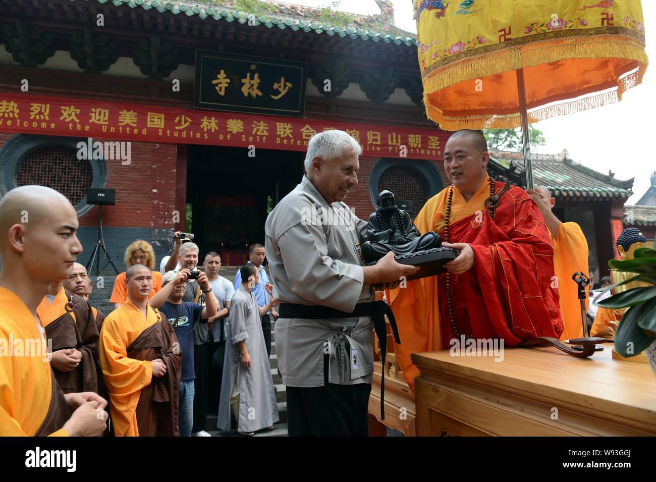 The abbot of Shaolin Temple, right, awards a statue of Buddha to an ...