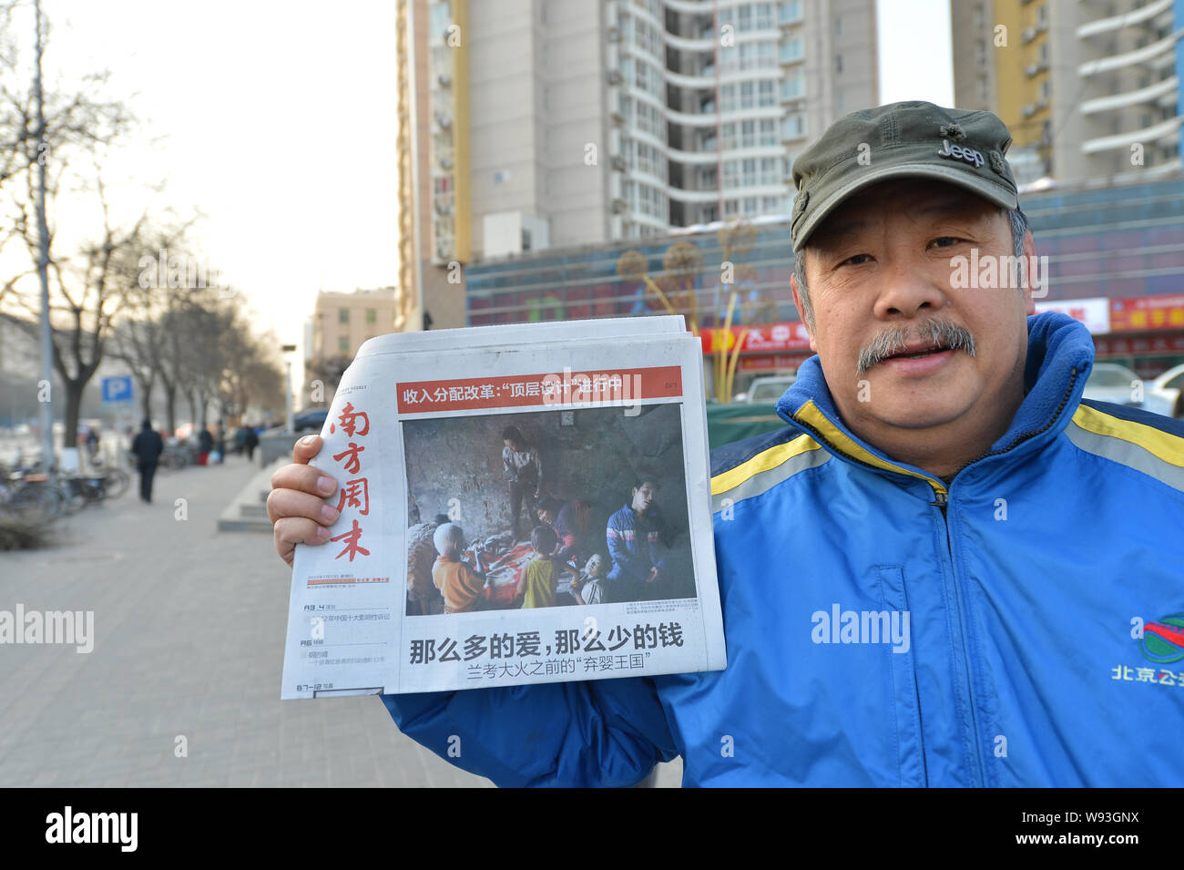 A Chinese man displays the latest edition of Southern Weekly at a ...