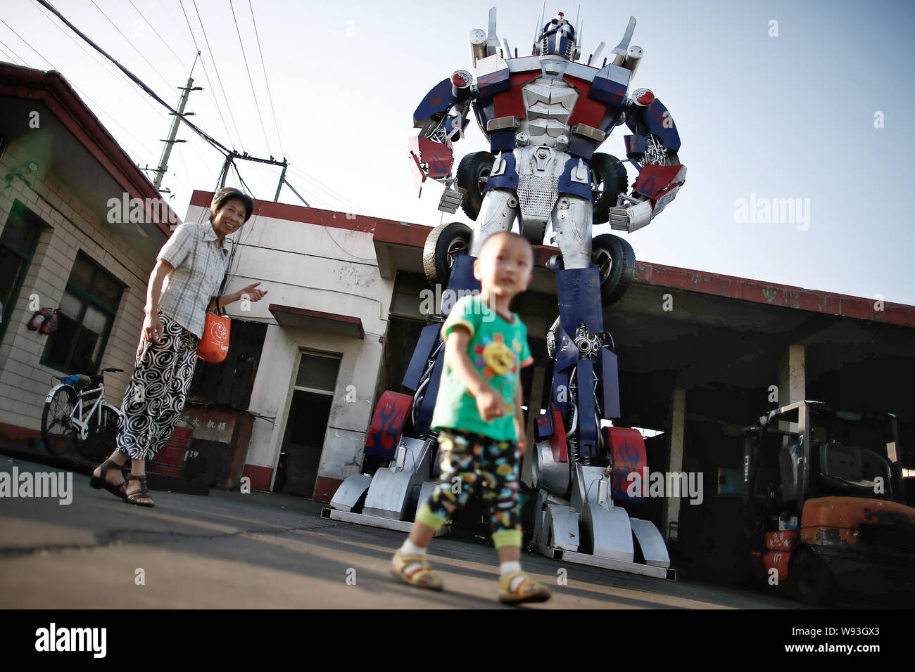 Pedestrians walk past a giant model of Optimus Prime, the leader of ...