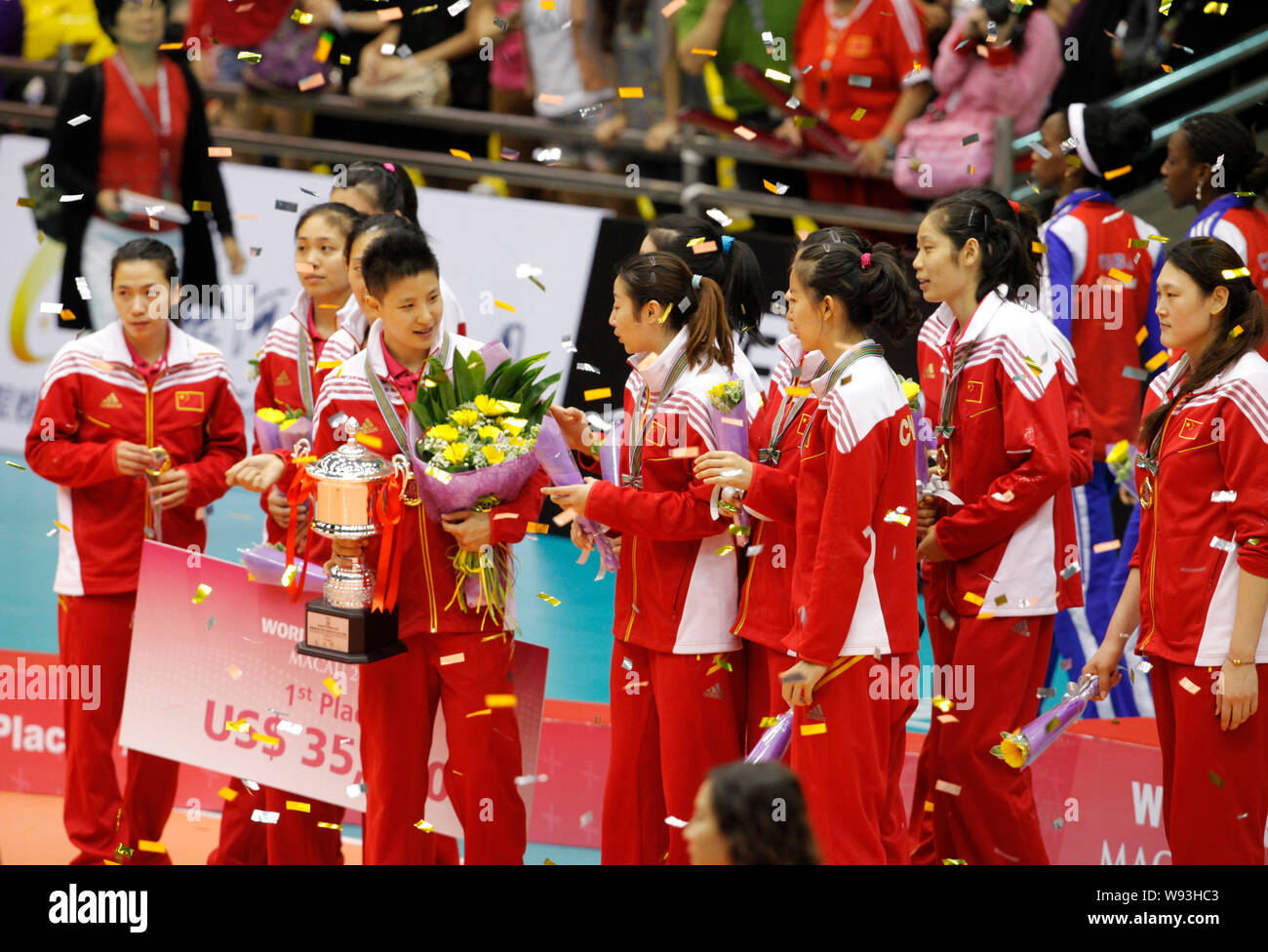Female Chinese volleyball players hold the trophy and bouquets of ...