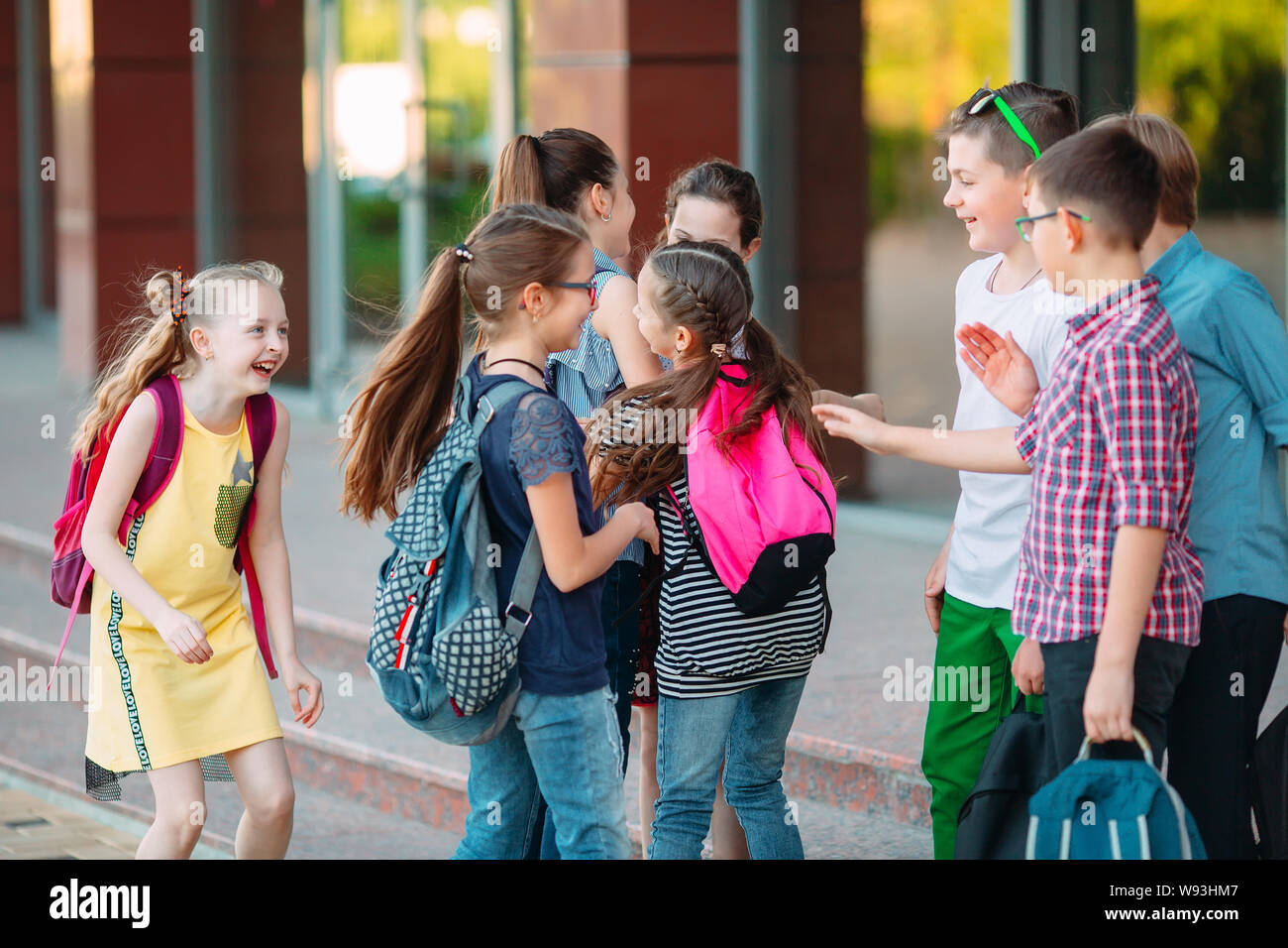 Schoolmates go to school. Students greet each other Stock Photo - Alamy