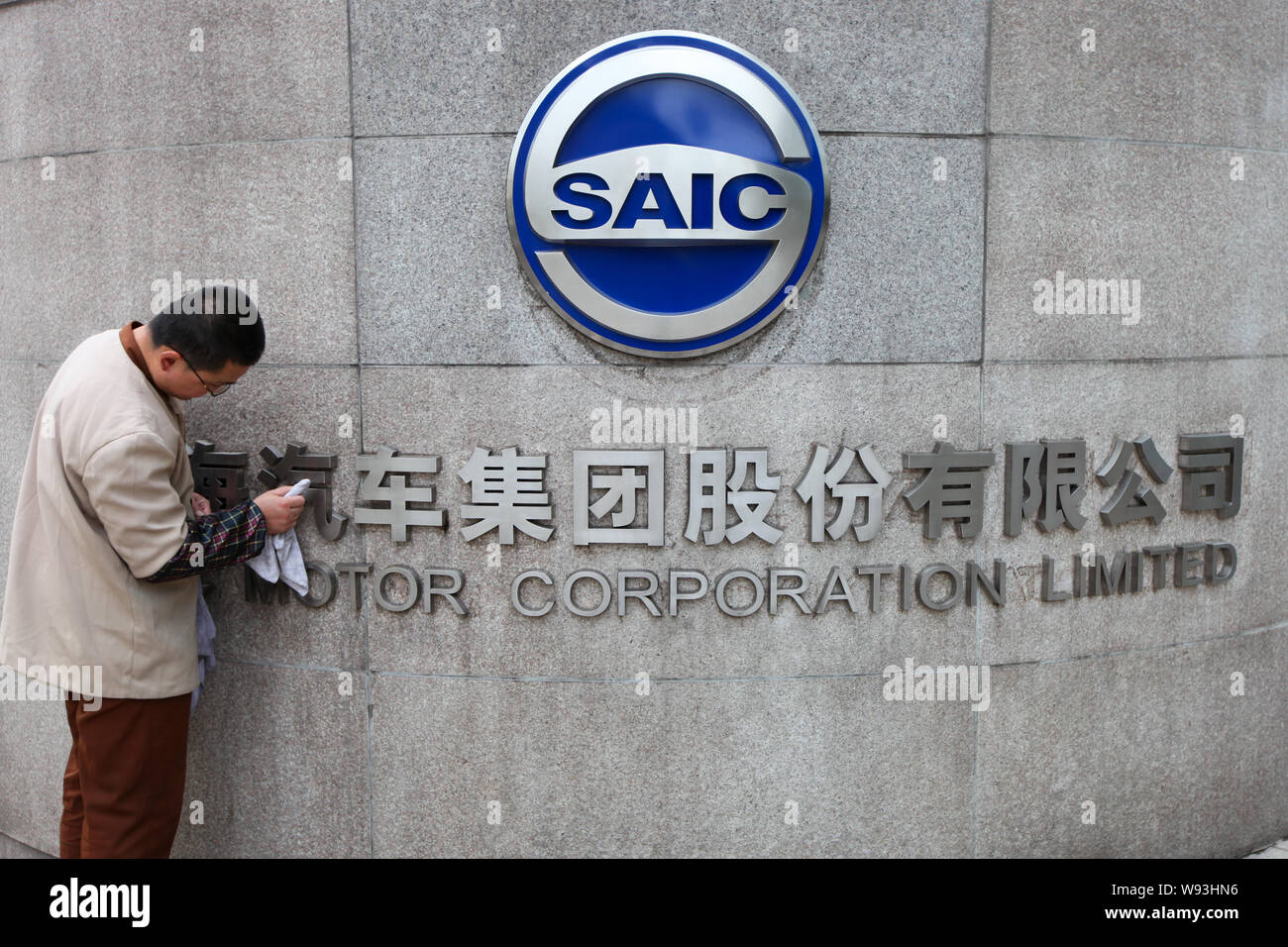 --FILE--A Chinese worker dusts off the logo of SAIC Motor Corporation ...