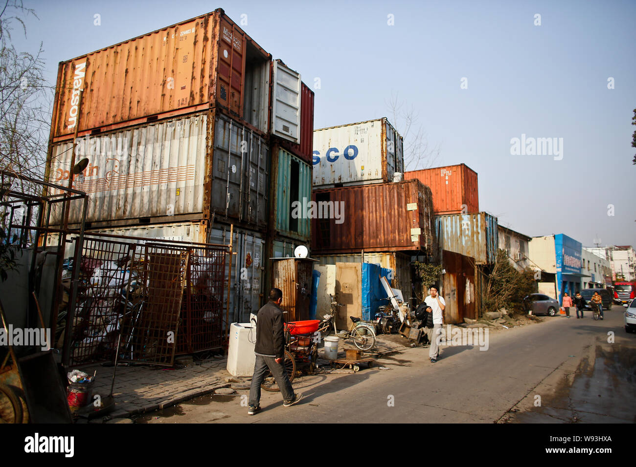 Pedestrians walk past homes converted from shipping containers in the ...