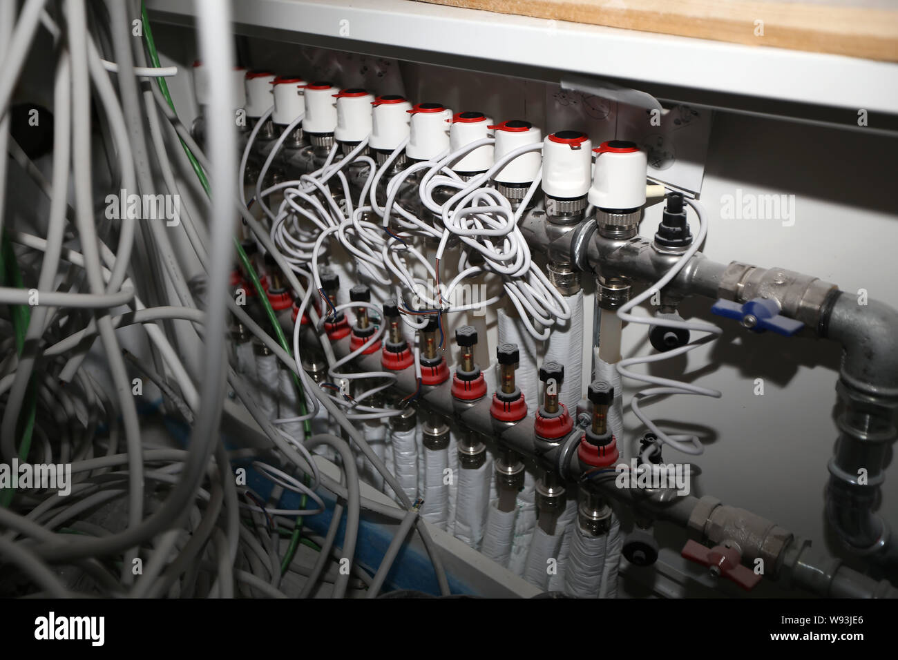 Plumbing in a new house. Central heating distributor Stock Photo - Alamy