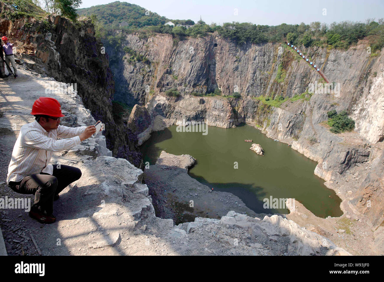 A man takes photos of the construction site of InterContinental Shimao ...