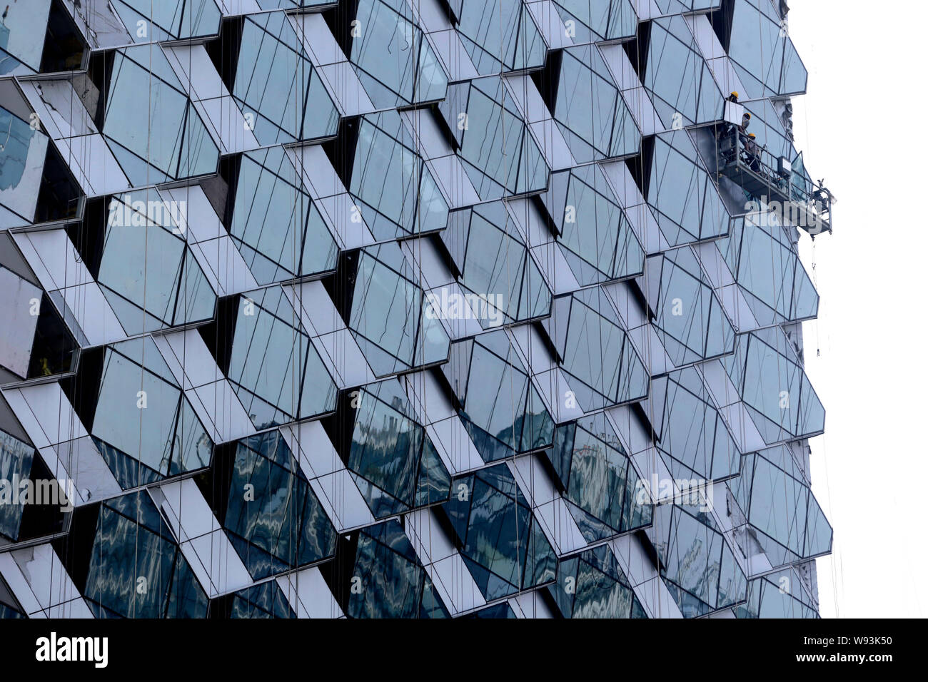 Chinese workers install glass on the facade of the seven-star hotel ...