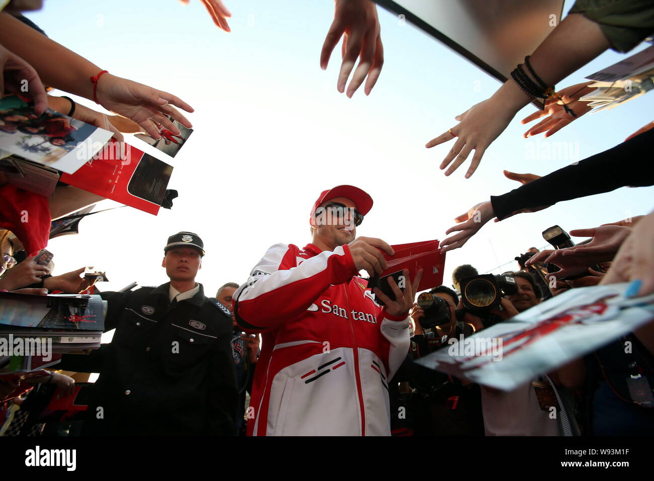 Spanish F1 driver Fernando Alonso of Ferrari distributes flyers to fans ...