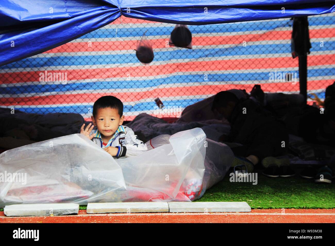 A young boy affected by the 7.0-magnitude earthquake looks out from a ...