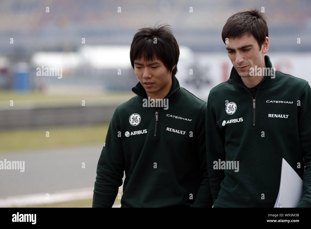 Chinese racer Ma Qinghua of Caterham, left, and his teammates walk ...