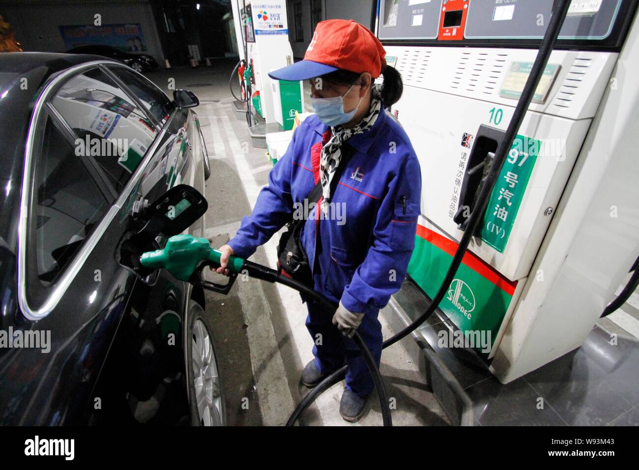 A Chinese worker refuels a car at a gas station of Sinopec in Nanjing ...