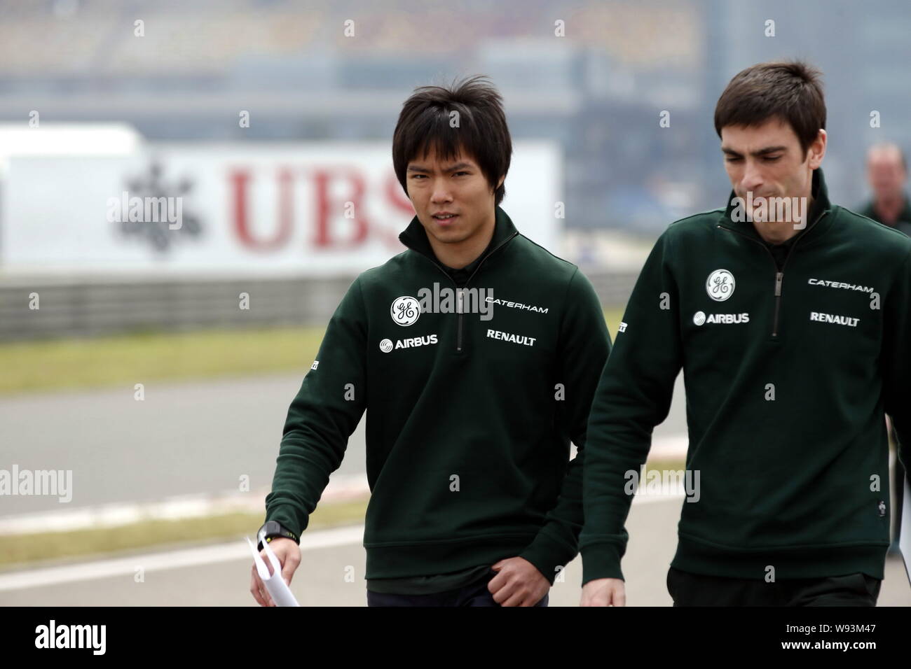 Chinese racer Ma Qinghua of Caterham, left, and his teammates walk ...
