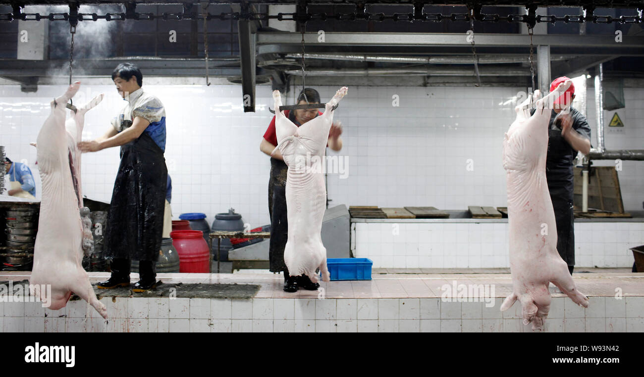 Chinese workers process killed pigs at a slaughterhouse in Haining city ...