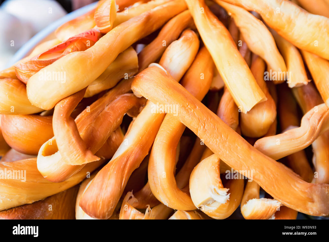 Smoked braided cheese strips close up background Stock Photo - Alamy