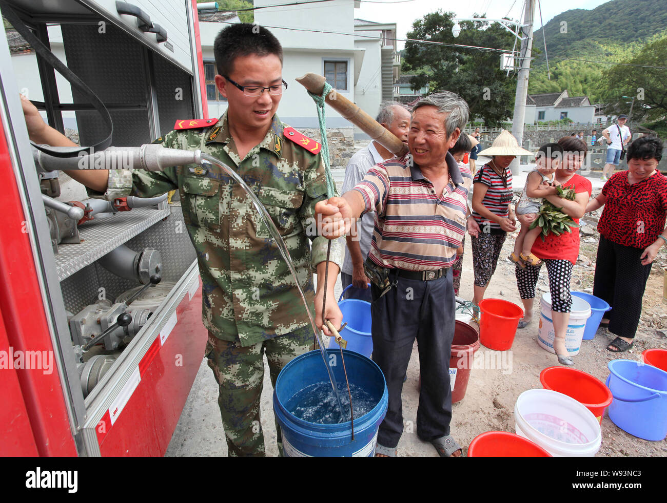 A Chinese firefighter discharges water from a fire engine to fill the ...