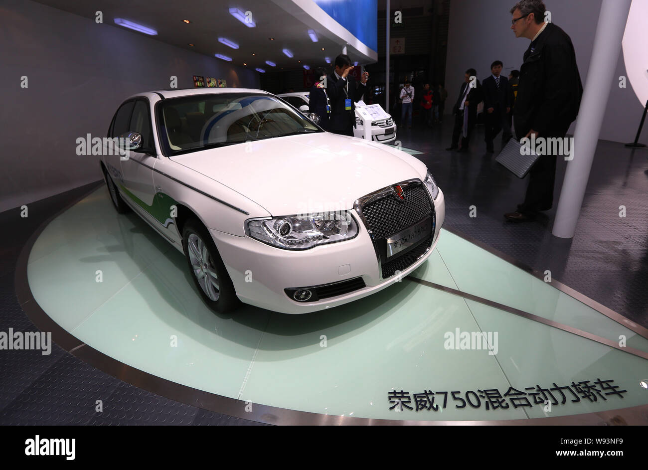 Visitors look at a Roewe 750 Hybrid of SAIC Motor during the 15th ...
