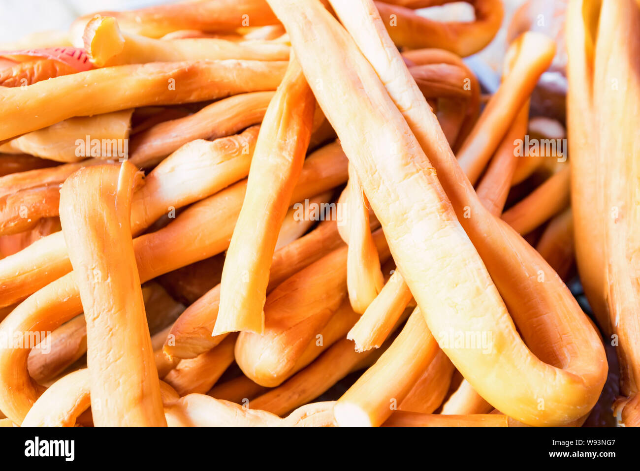 Smoked braided cheese strips close up background Stock Photo - Alamy
