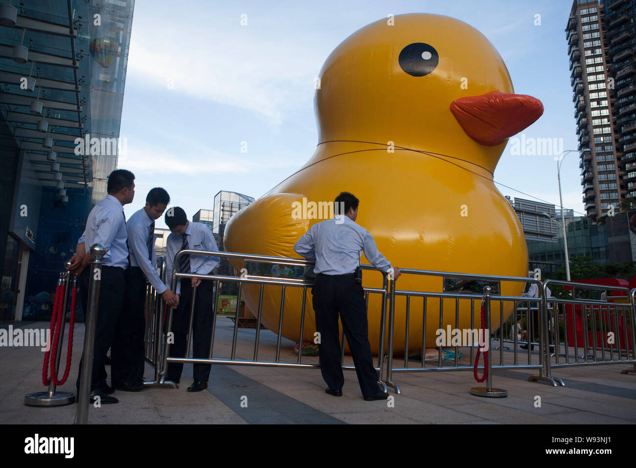 Security guards install guardrails around an inflatable yellow duck ...