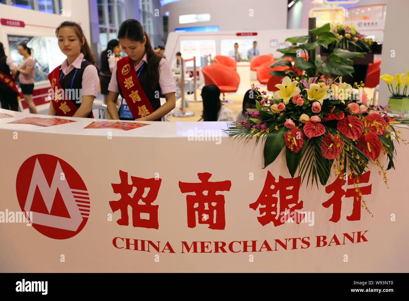 --FILE--Chinese employees welcome visitors at the stand of China ...