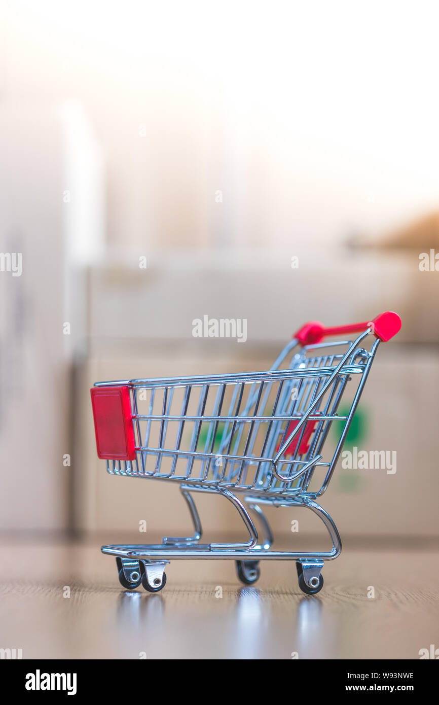 Online-Shopping and parcel service concept: Miniature shopping cart and ...