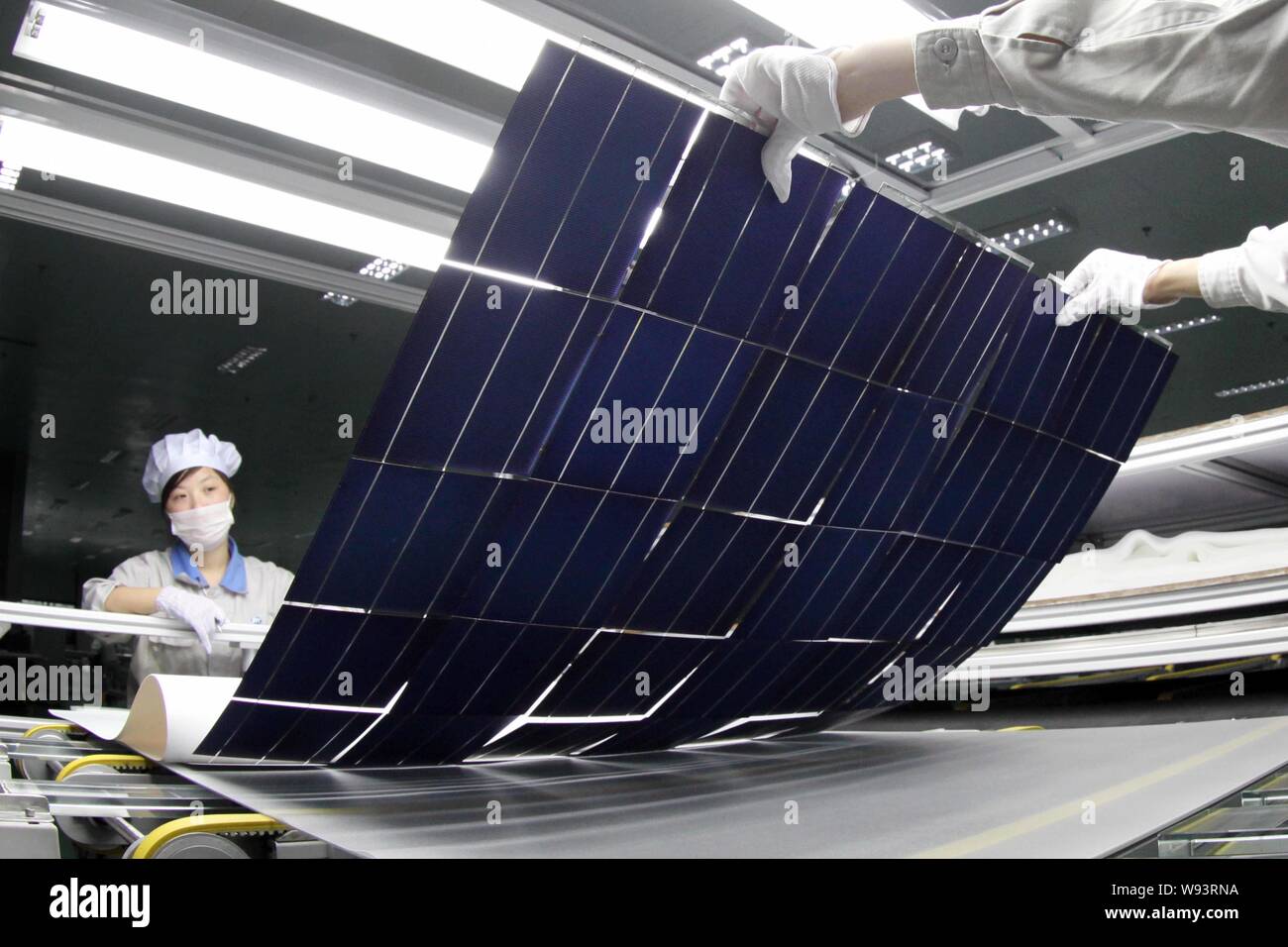--FILE--Female Chinese workers examine photovoltaic cells of solar ...