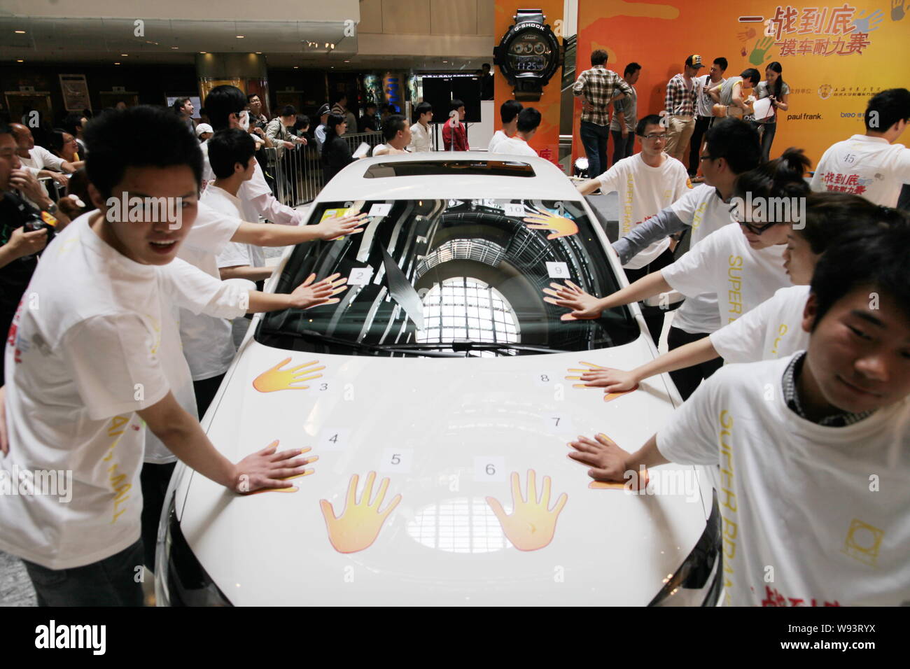 Chinese contestants keep their hands on a Volkswagen Polo GTI during a ...