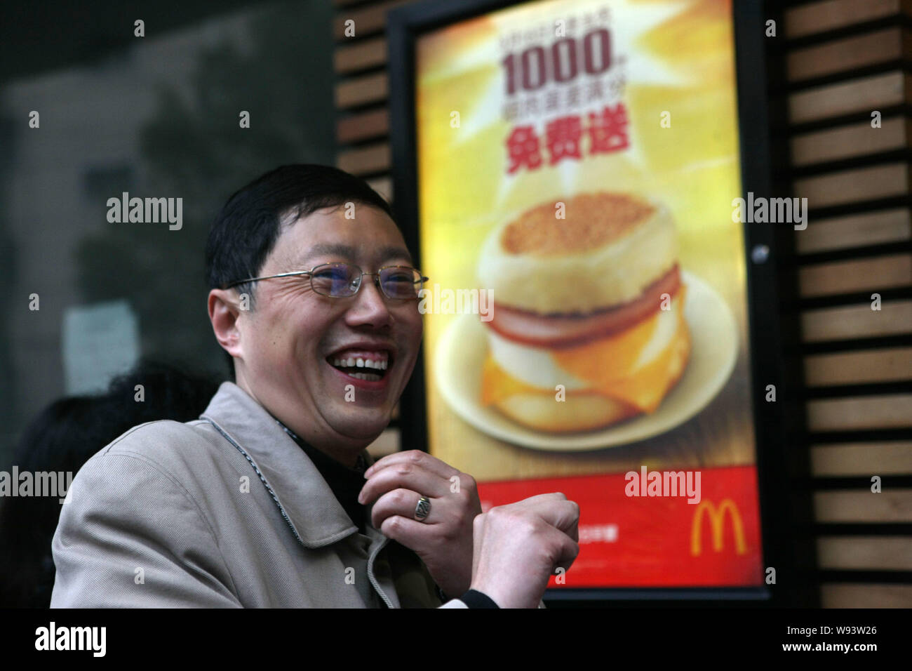 A Chinese man laughes as he queues up with others for free McMuffins ...