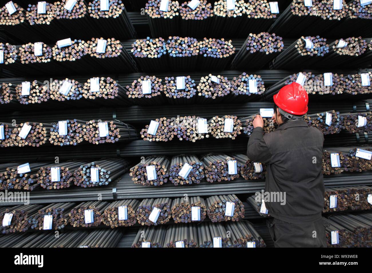 --FILE--A Chinese worker labels reinforcing steel rods at a steel plant ...