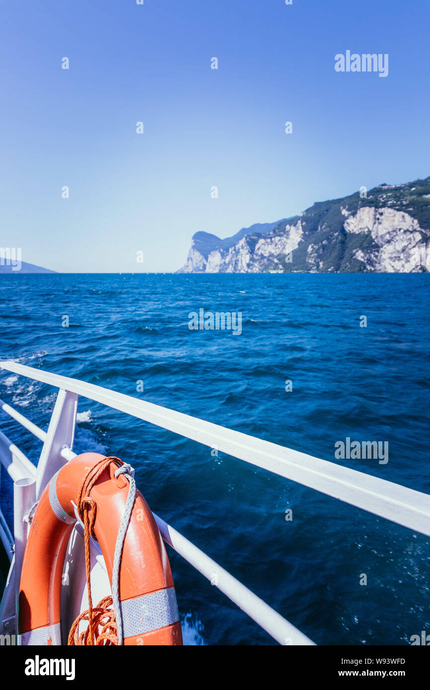Railing of a boat, boat tour. Blue water and mountain range, Lago di ...