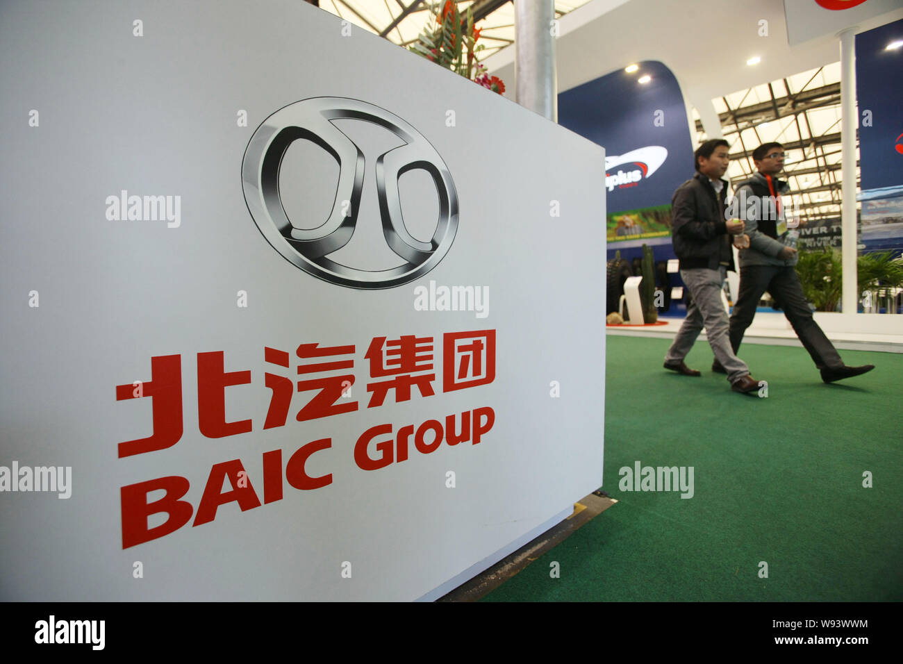 --FILE--Visitors walk past the stand of BAIC Group, also known as ...