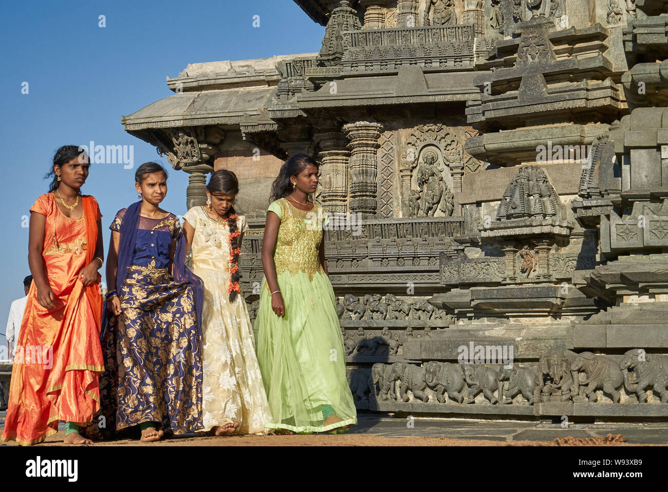 four traditional dressed girls on Belur Jain temple, Hassan, Karnataka ...