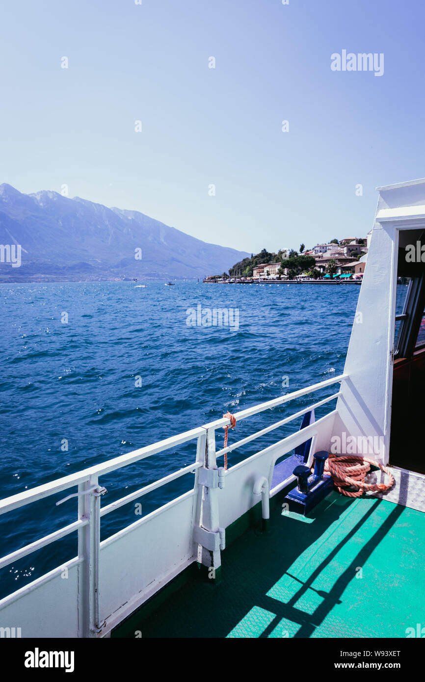 Railing of a boat, boat tour. Blue water and mountain range, Lago di ...