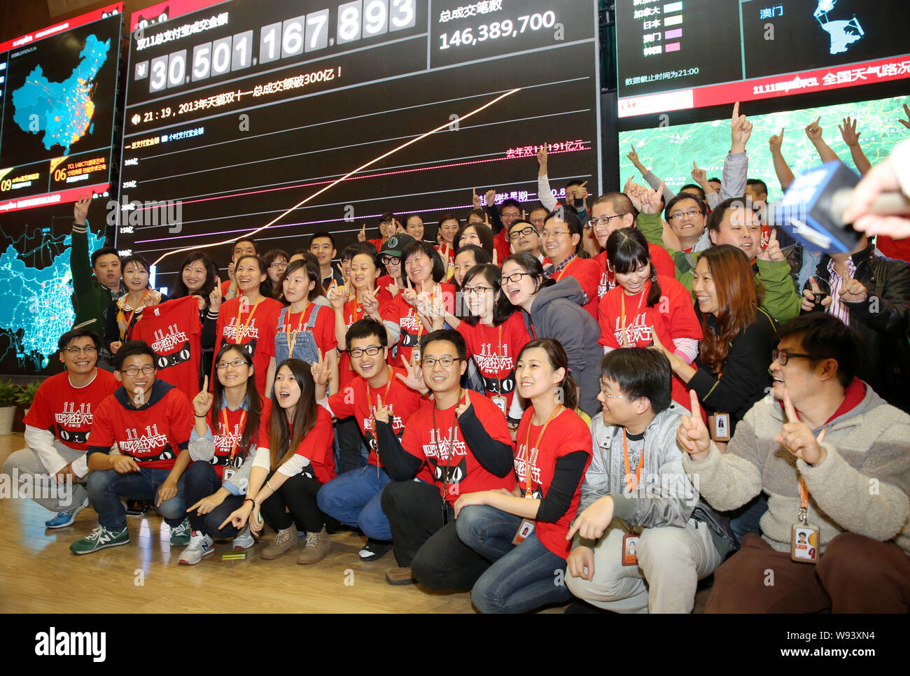 Chinese employees celebrate and pose for photos in front of a big ...
