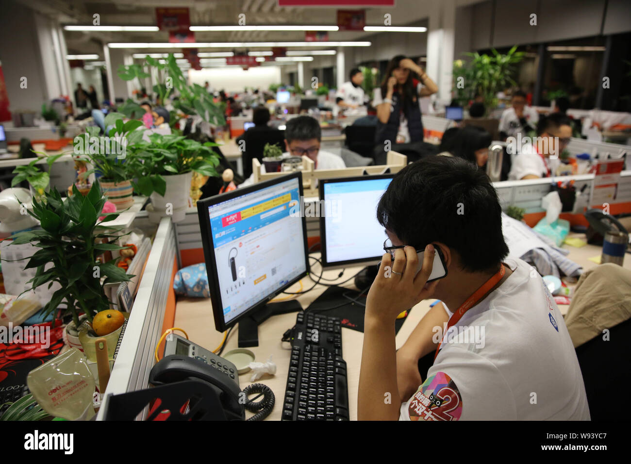 Chinese employees work at their desks at the headquarters of Chinese ...