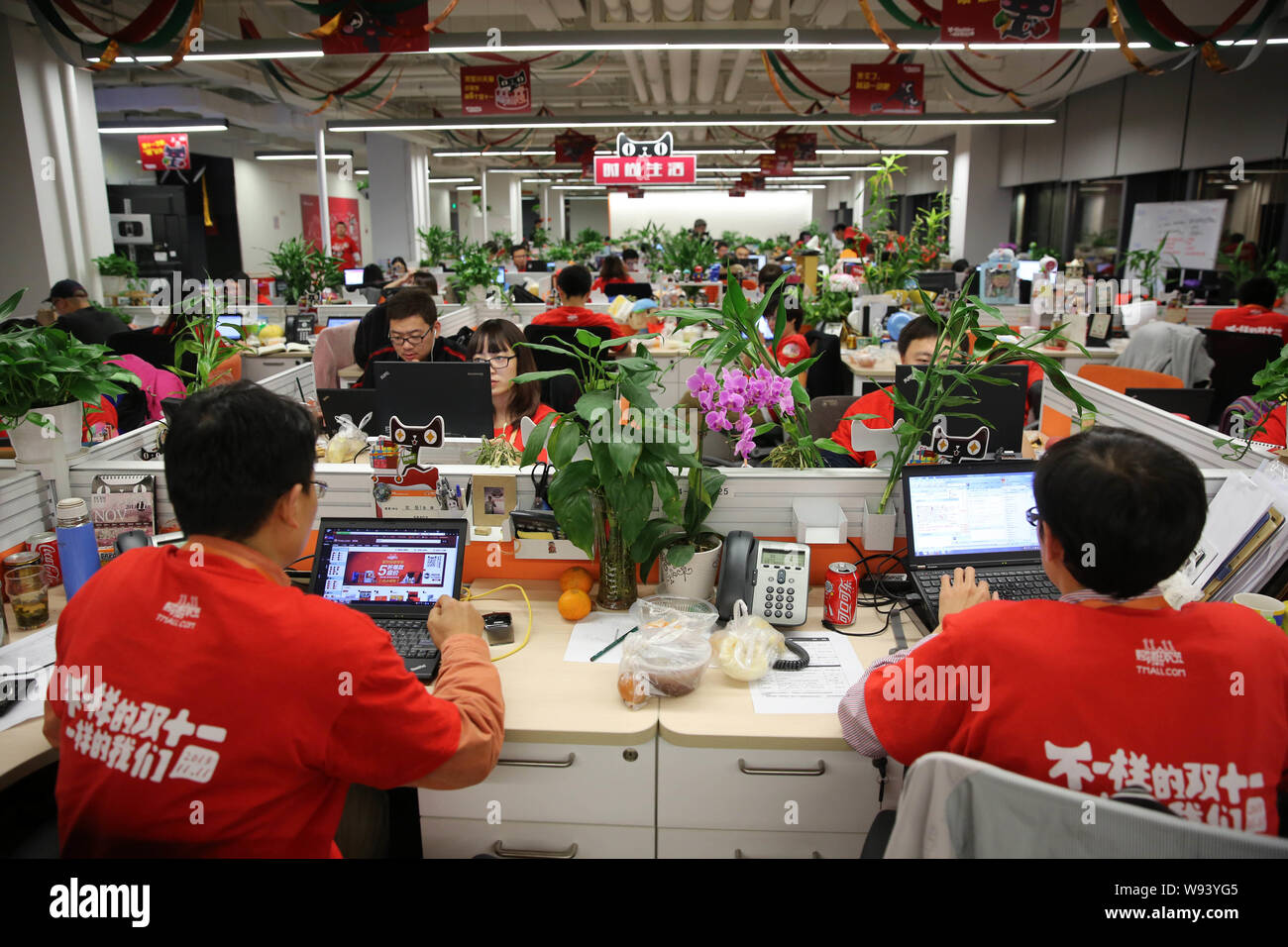 Chinese employees work at their desks at the headquarters of Chinese ...
