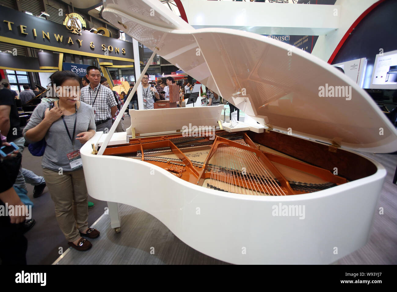 Visitors view pianos during the China (Shanghai) International Musical ...