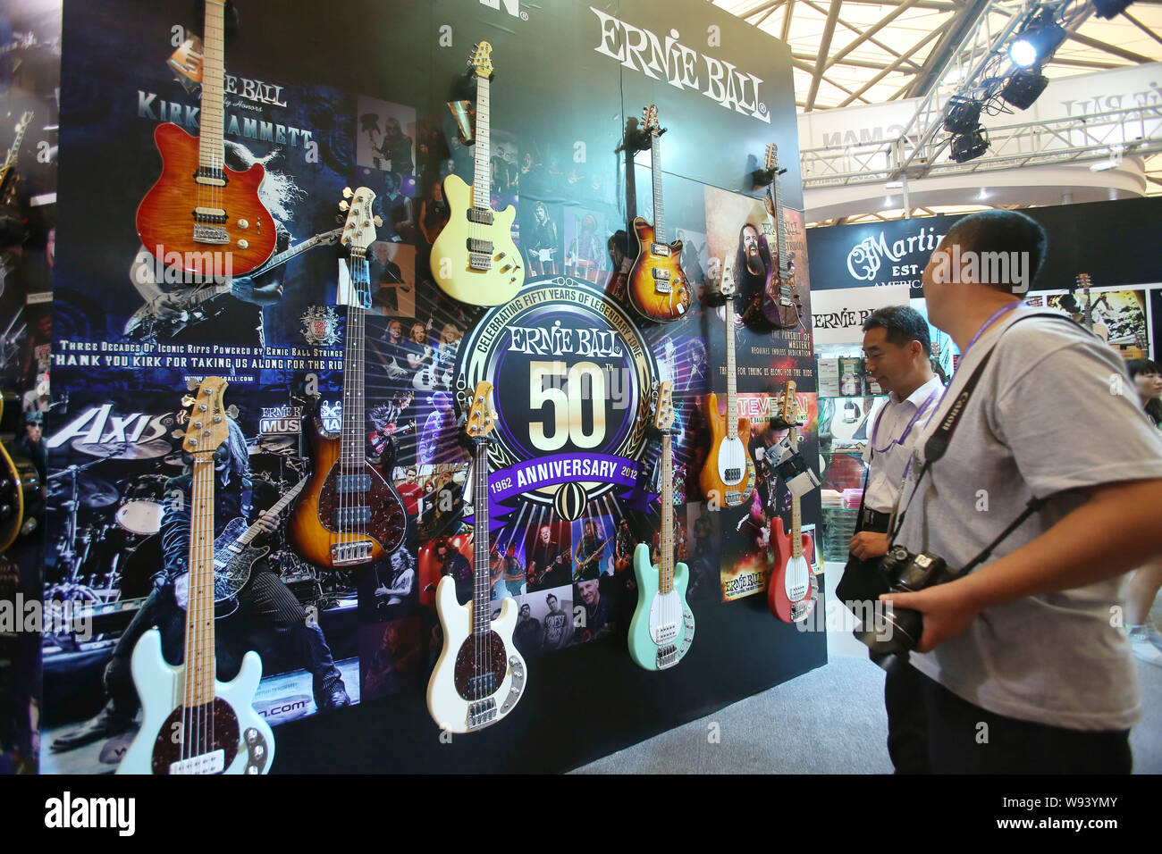 Visitors view electronic guitars of Ernie Ball during the China ...