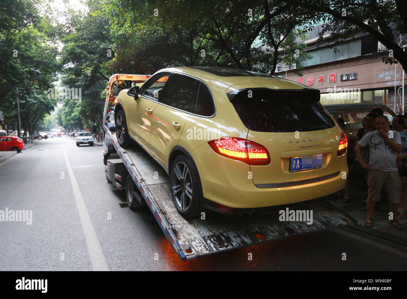 The Porsche Cayenne SUV is loaded onto a tow truck after ramming into ...