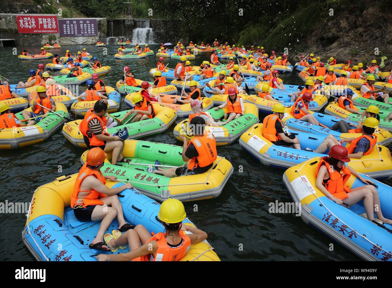 A crowd of holidaymakers sitting in life rafts wait for a waterfall ...