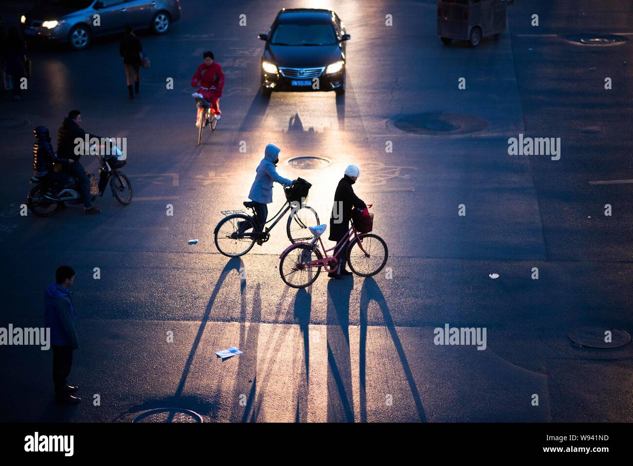 Cyclists ride through an intersection in Beijing, China, 9 April 2013 ...