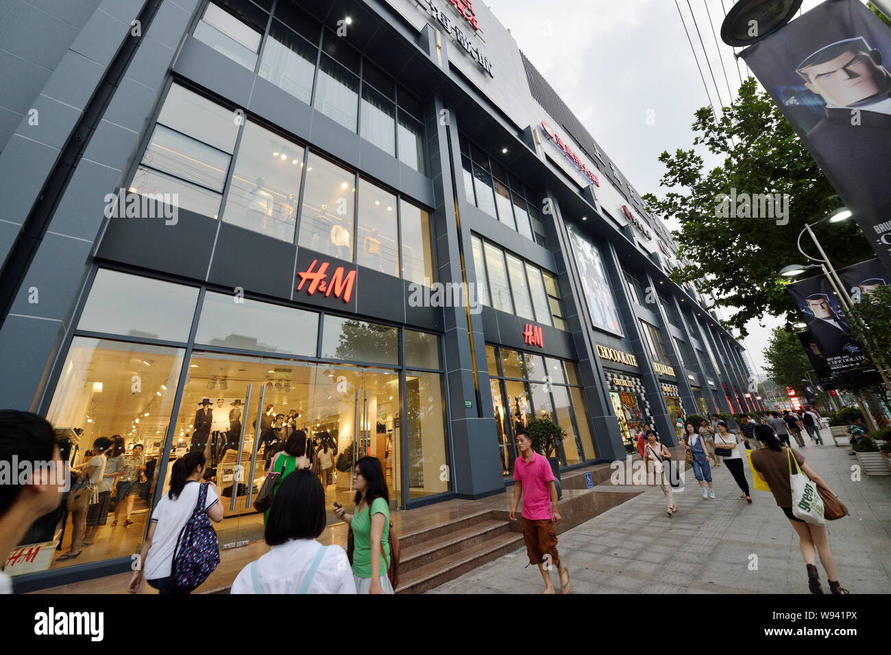 --FILE--Pedestrians walk past a fashion store of H&M in Shanghai, China ...