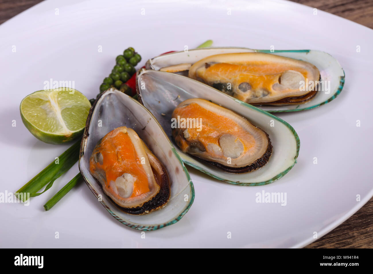 Half mussels with lime and green pepper Stock Photo - Alamy