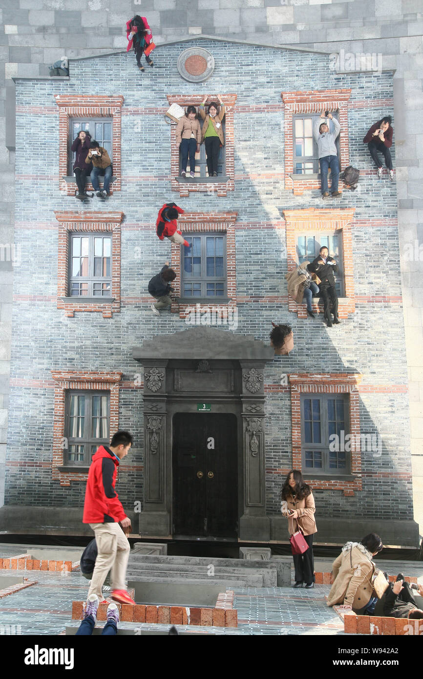 Visitors pose on a model of Shikumen building on the ground, looking at ...